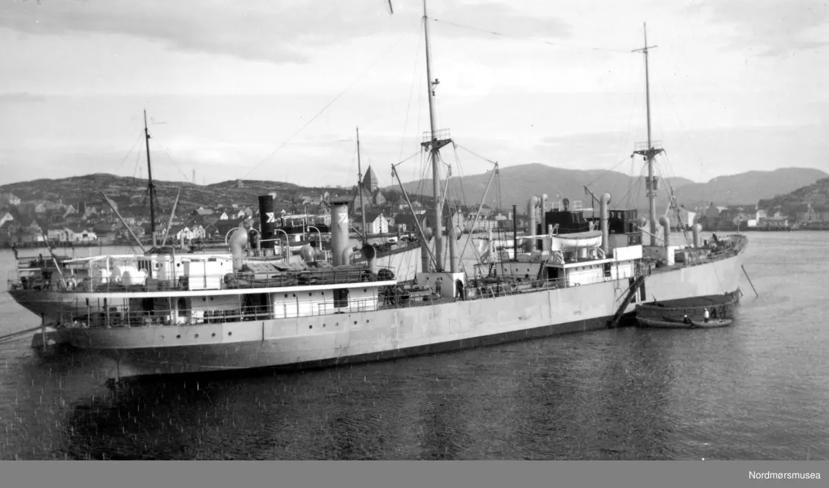 To lasteskip på havna i Kristiansund. I bakgrunnen kan vi se Nordlandet ...